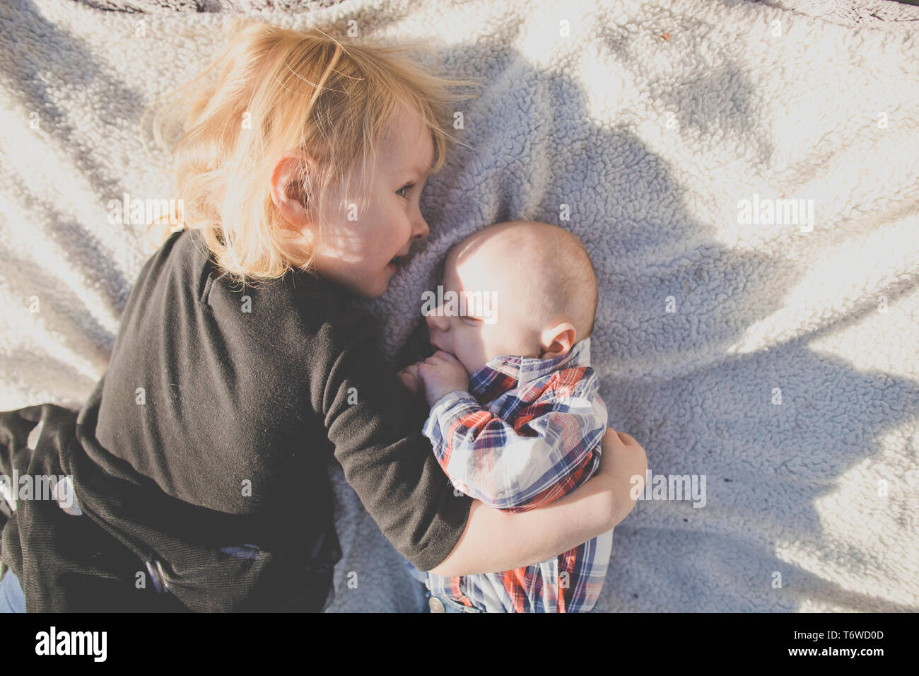 Brother and sister lay on cozy blanket Stock Photo - Alamy