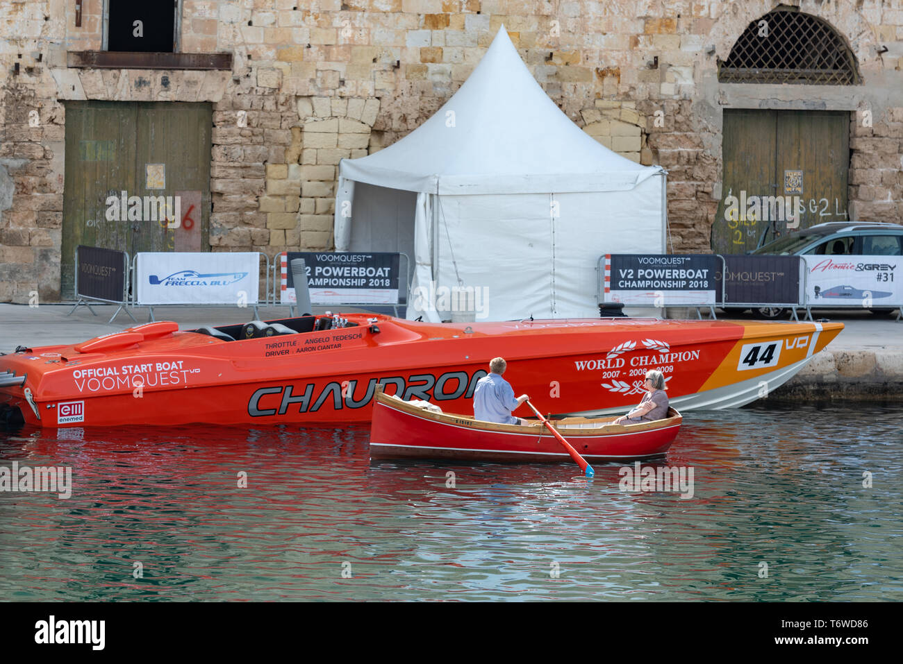 Boat envy! A man in a red rowing boat admires the high powered Official ...