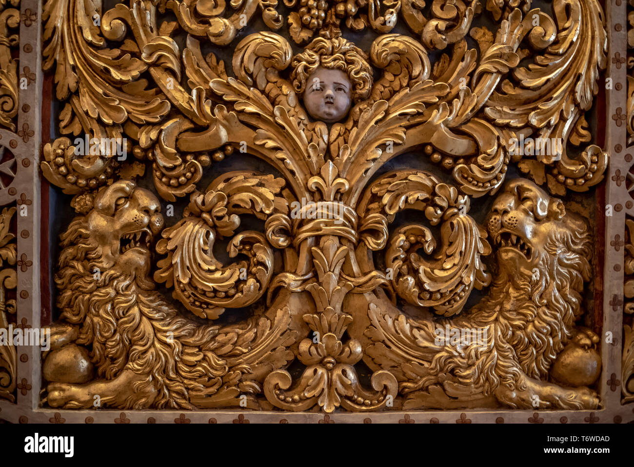 Detail of an intricately carved stone cartouche covered in gilded ...