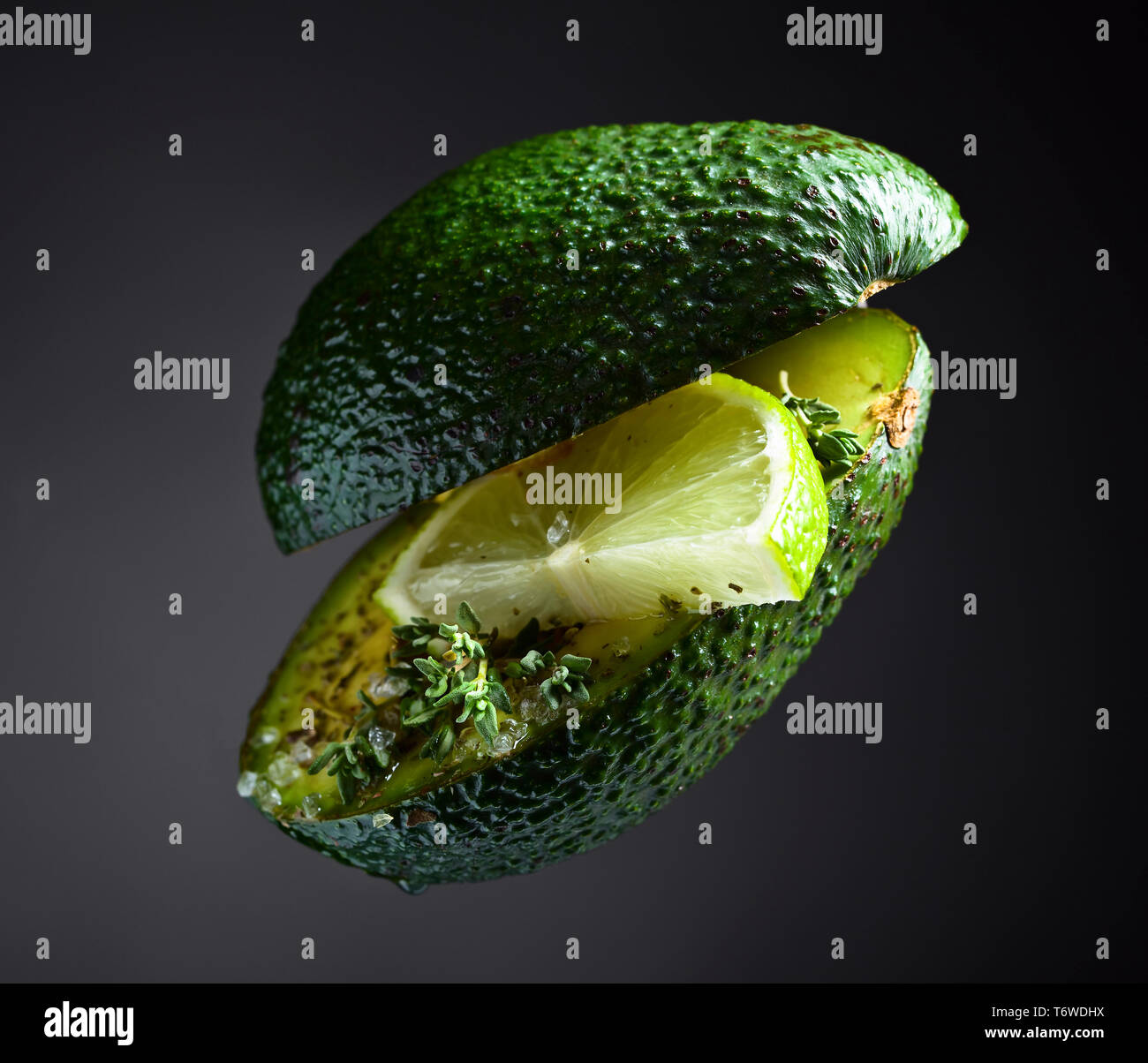 Avocado with lime, thyme and sea salt on a black background Stock Photo ...
