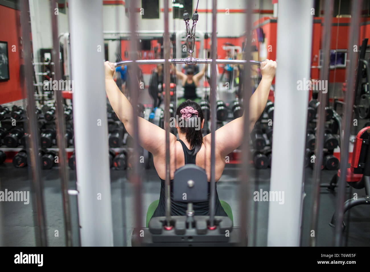 Strong woman completes shoulder pull-down at the gym Stock Photo - Alamy