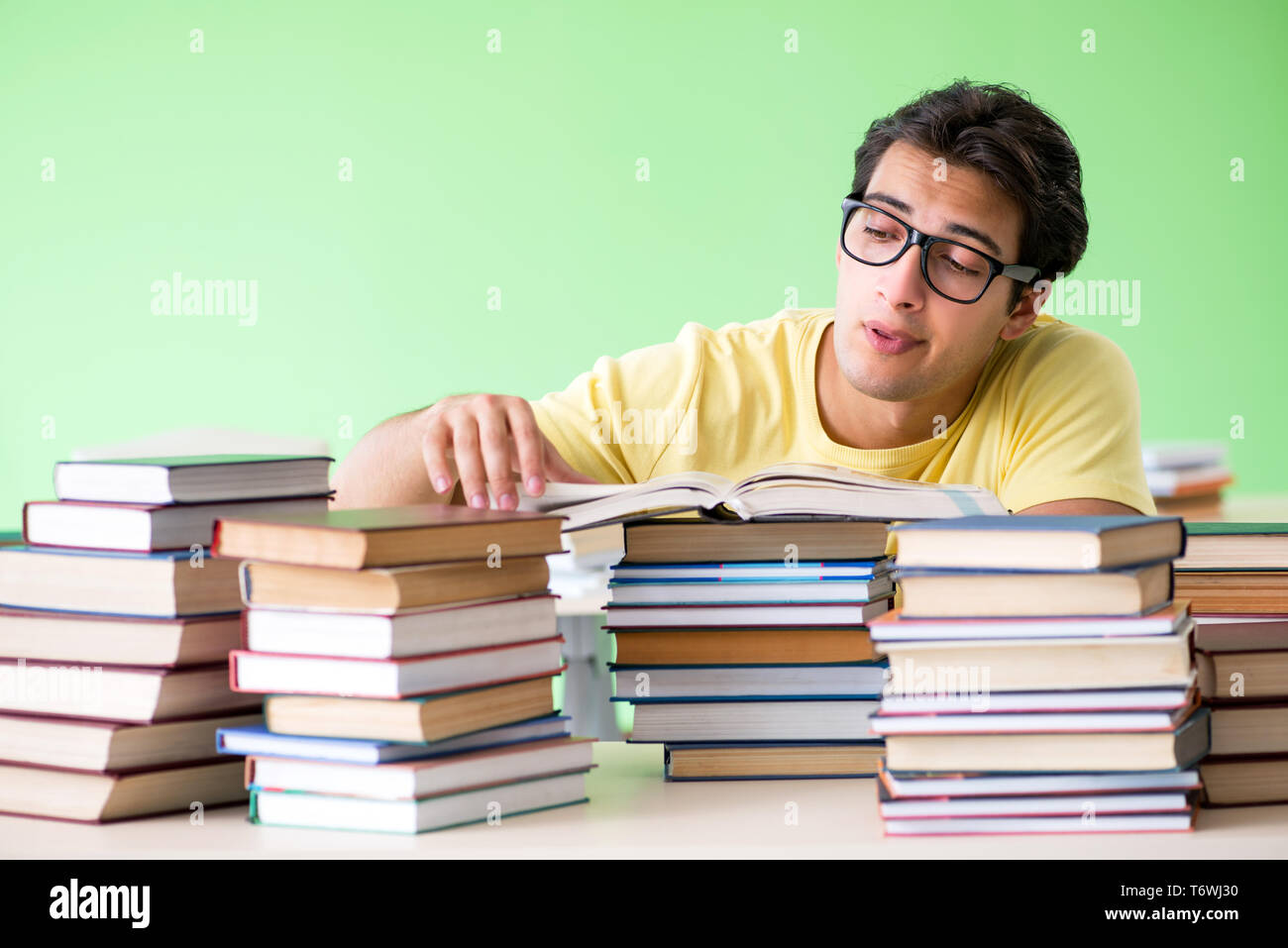 Student with too many books to read before exam Stock Photo - Alamy