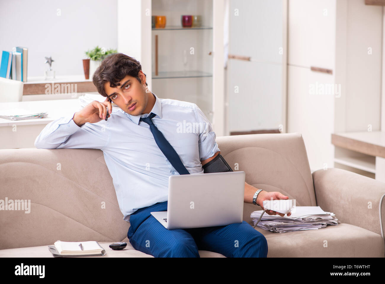 Man under stress measuring his blood pressure Stock Photo - Alamy