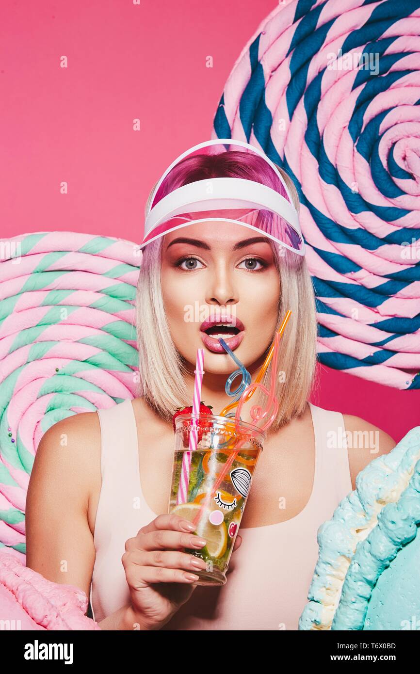 Beautiful girl drinking lemonade at pink background Stock Photo - Alamy