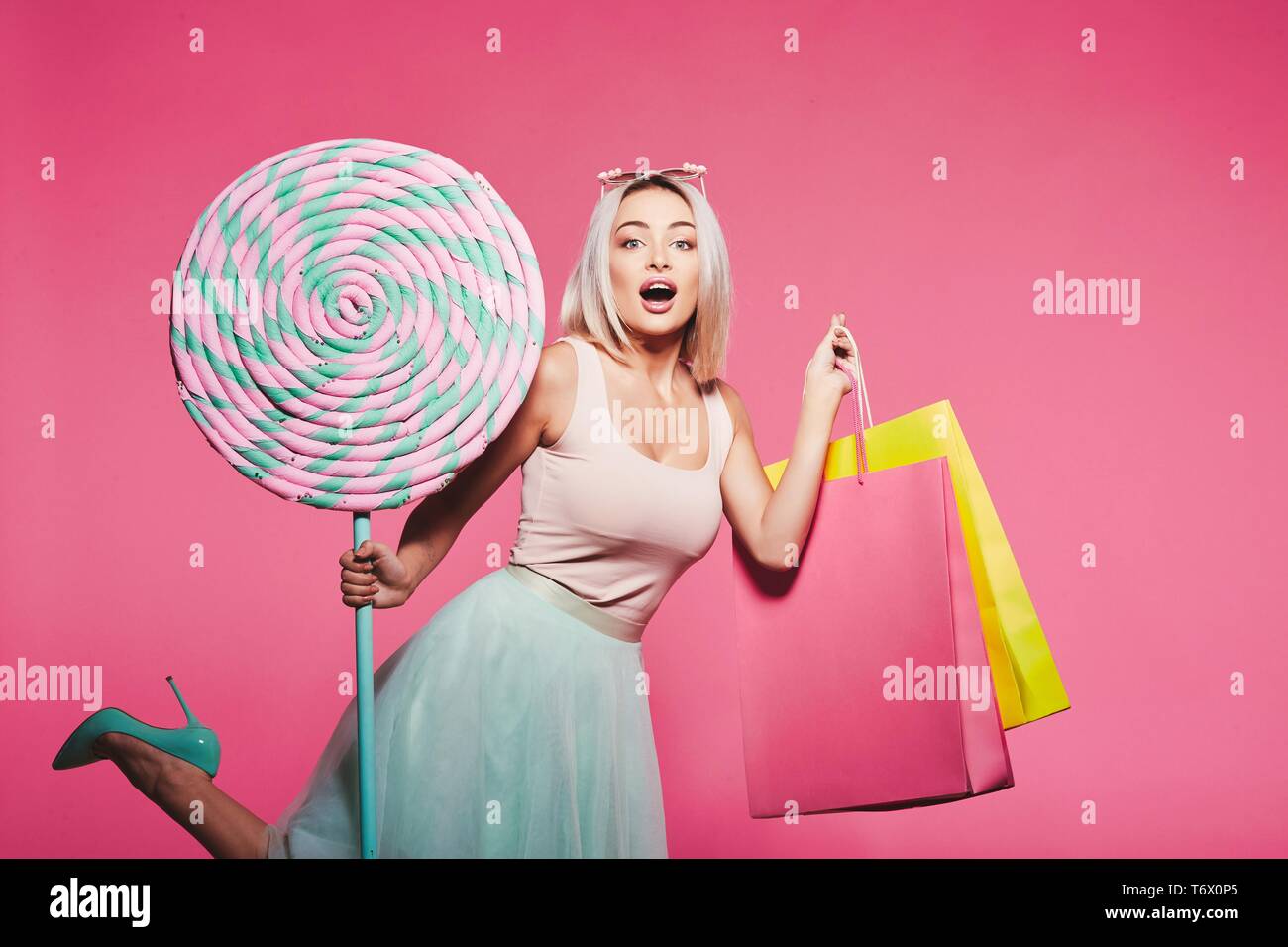 Model posing with with sweets and shopping bags Stock Photo - Alamy