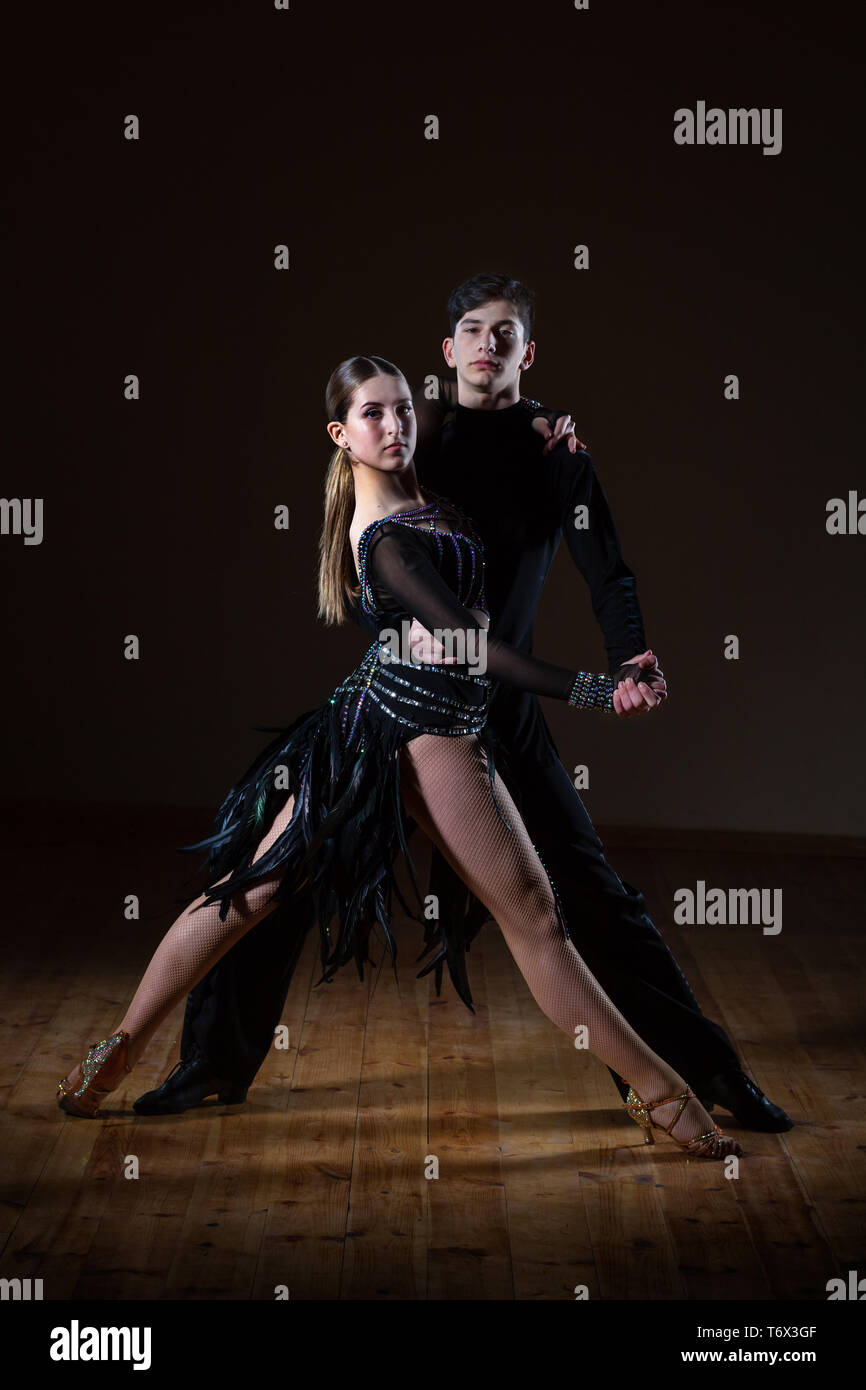 Beautiful young dancers in ballroom isolated on black background ...