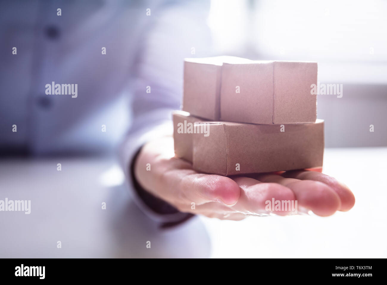 Close-up Of Hand Holding Stack Of Miniature Movable Cardboard Boxes On ...