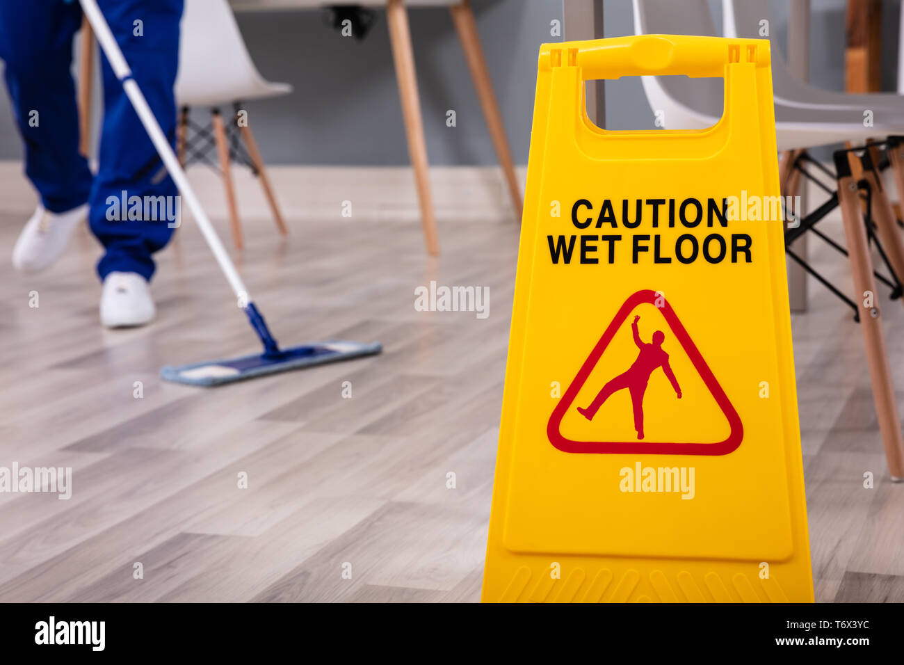 Male janitor with mop cleaning modern office floor Stock Photo - Alamy