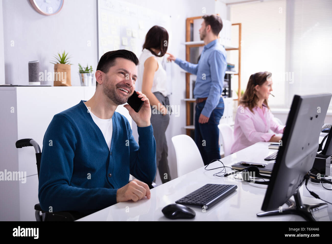 Disabled Man Sitting On Wheelchair Working On Computer In Office Stock ...