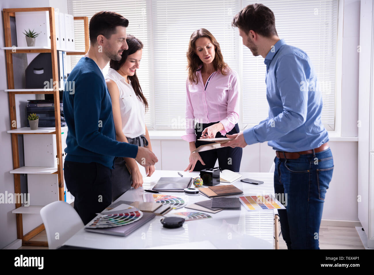 Group Of Young Businesspeople Working Together Choosing Color Palette ...