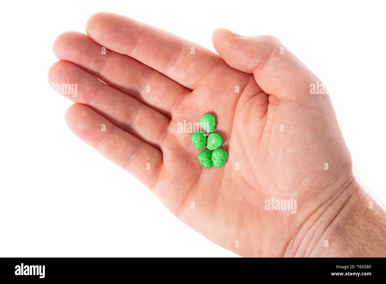 Topview palm caucasian male hand with a little pile of green Skull ...