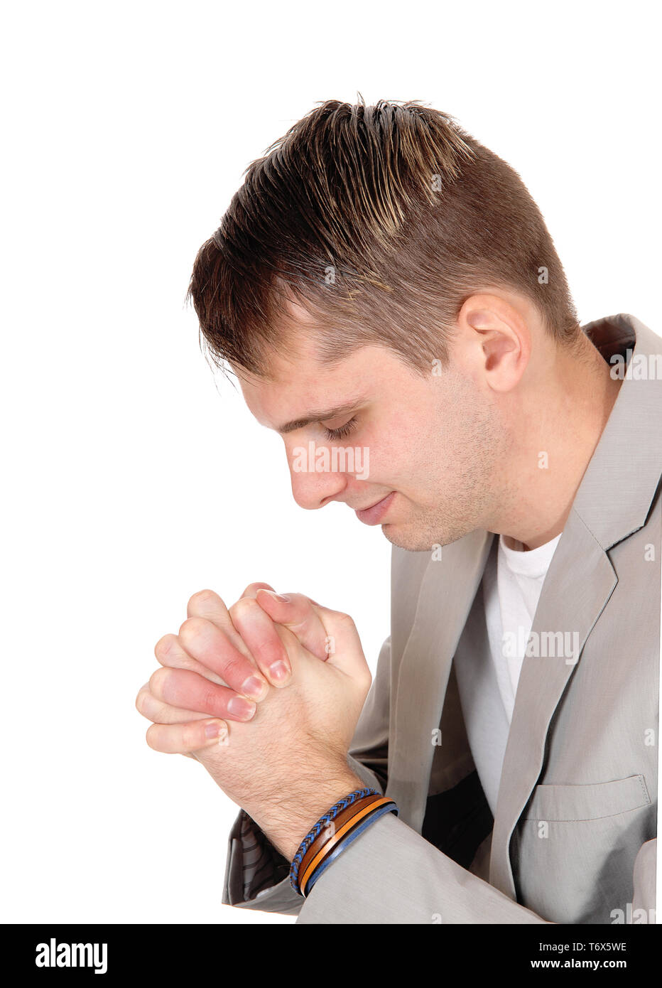 Young man praying with hands folded Stock Photo - Alamy