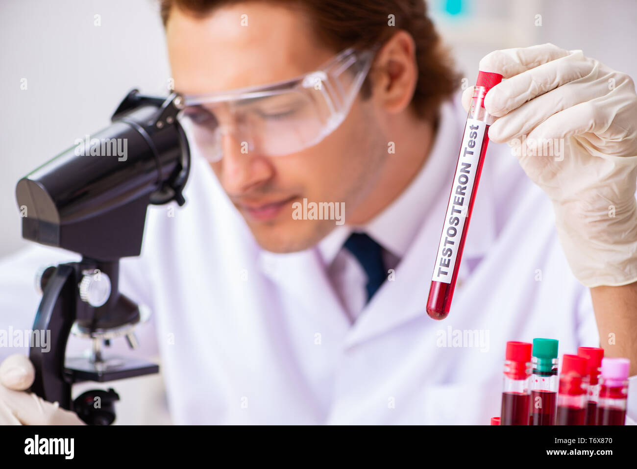 Young handsome lab assistant testing blood samples in hospital Stock ...