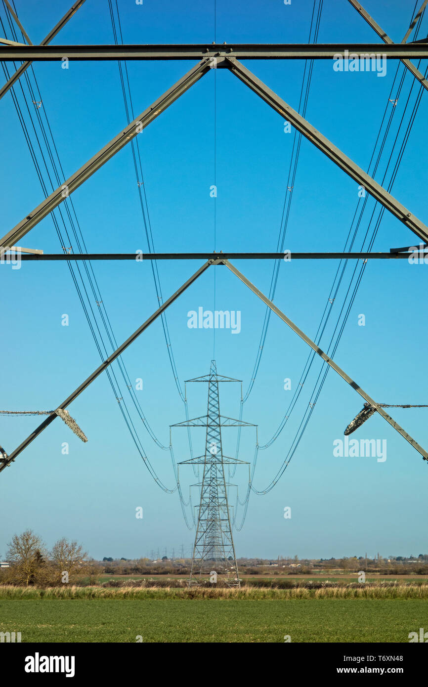 Line of electricity pylons with blue sky, Cambridgeshire, England, UK ...