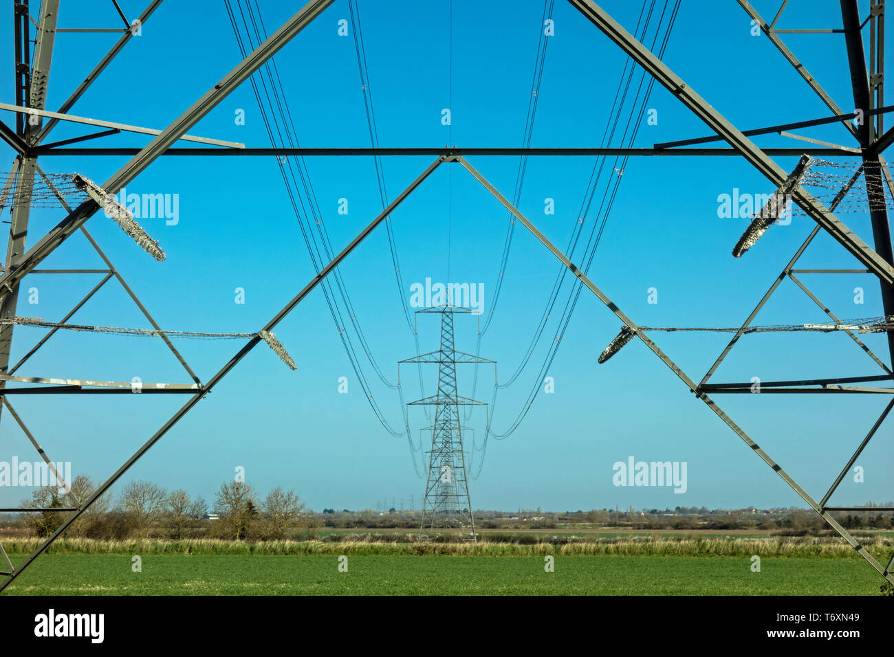 Line of electricity pylons with blue sky, Cambridgeshire, England, UK ...