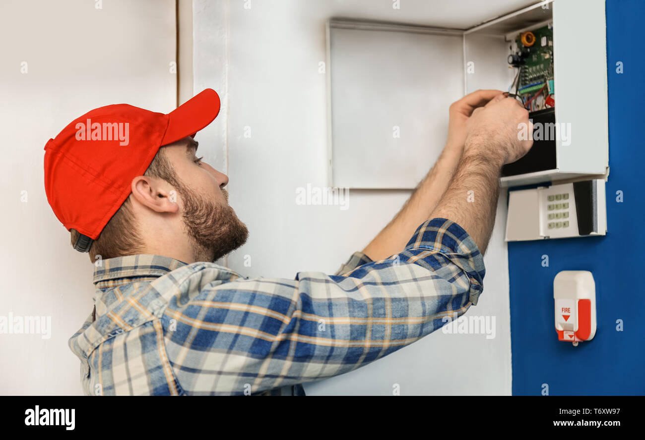 Young electrician installing alarm system Stock Photo - Alamy