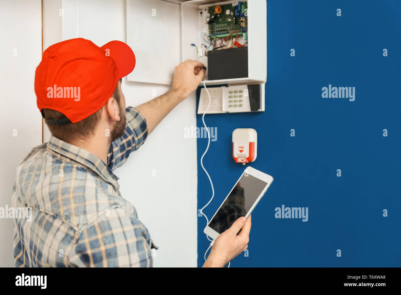 Young electrician installing alarm system Stock Photo - Alamy