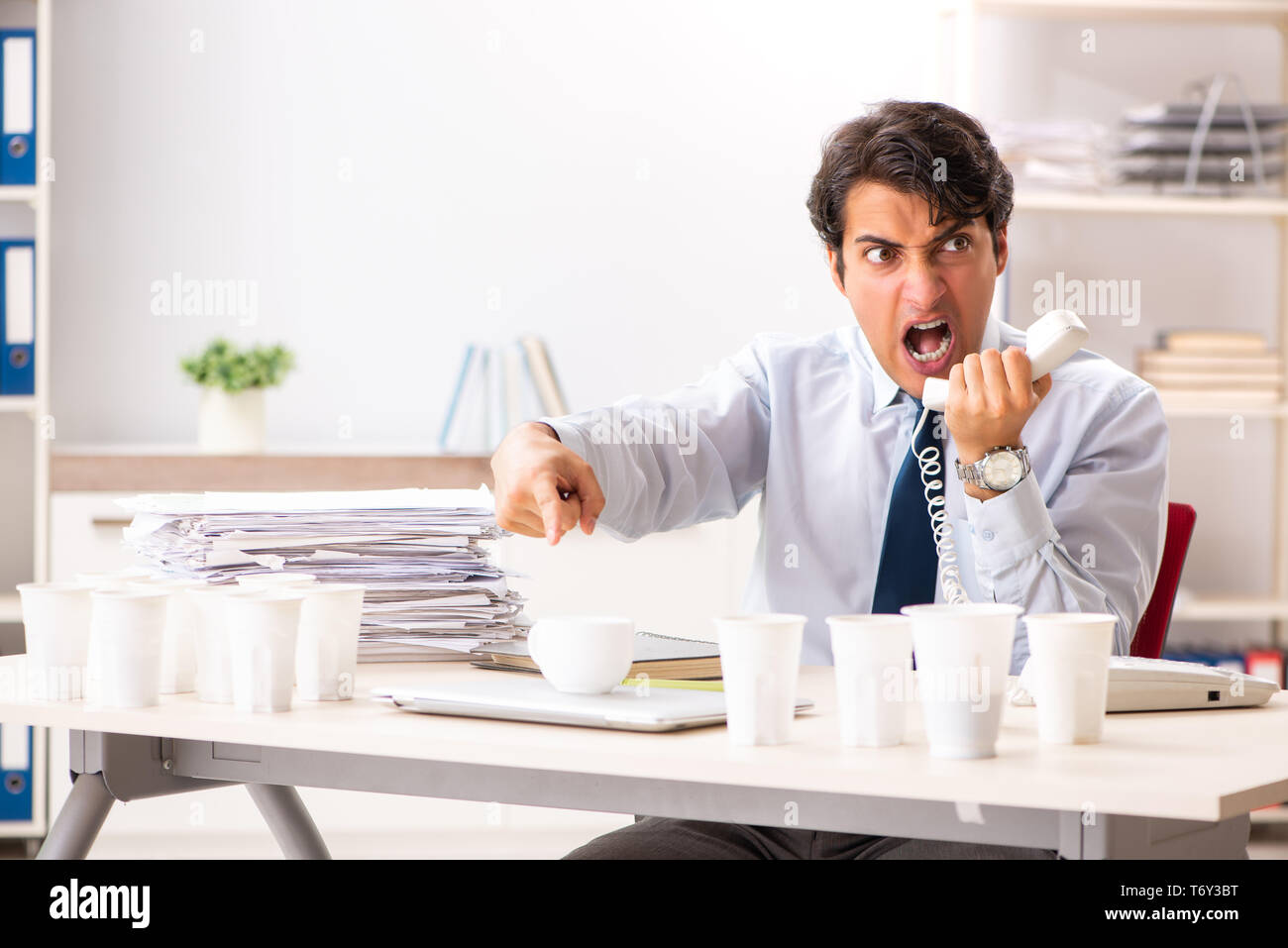 The young employee addicted to coffee Stock Photo - Alamy