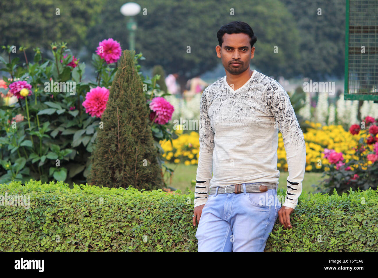 young man model standing in a garden with flower background Stock Photo ...