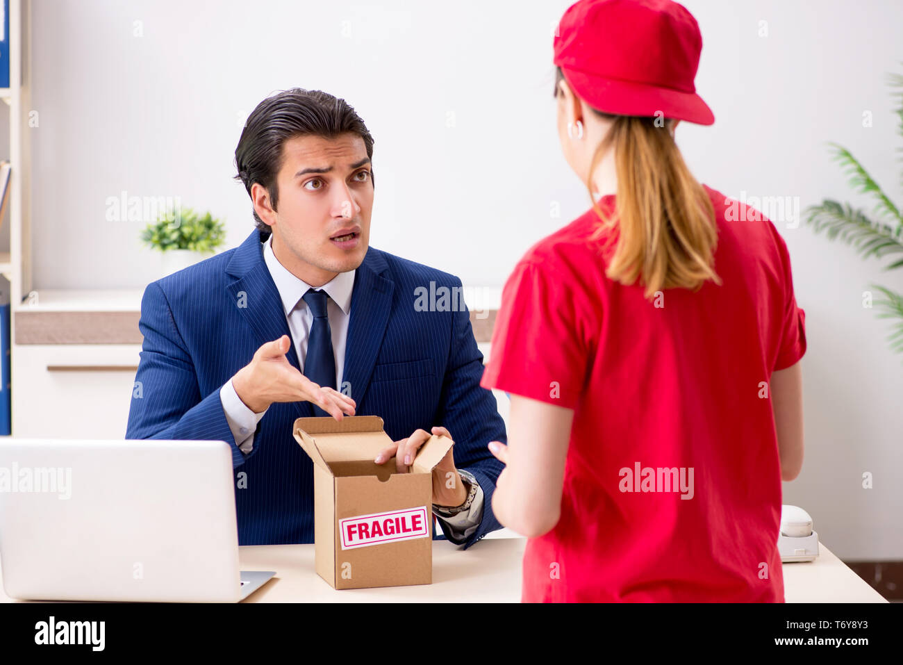 Courier delivering parcel to the office Stock Photo - Alamy