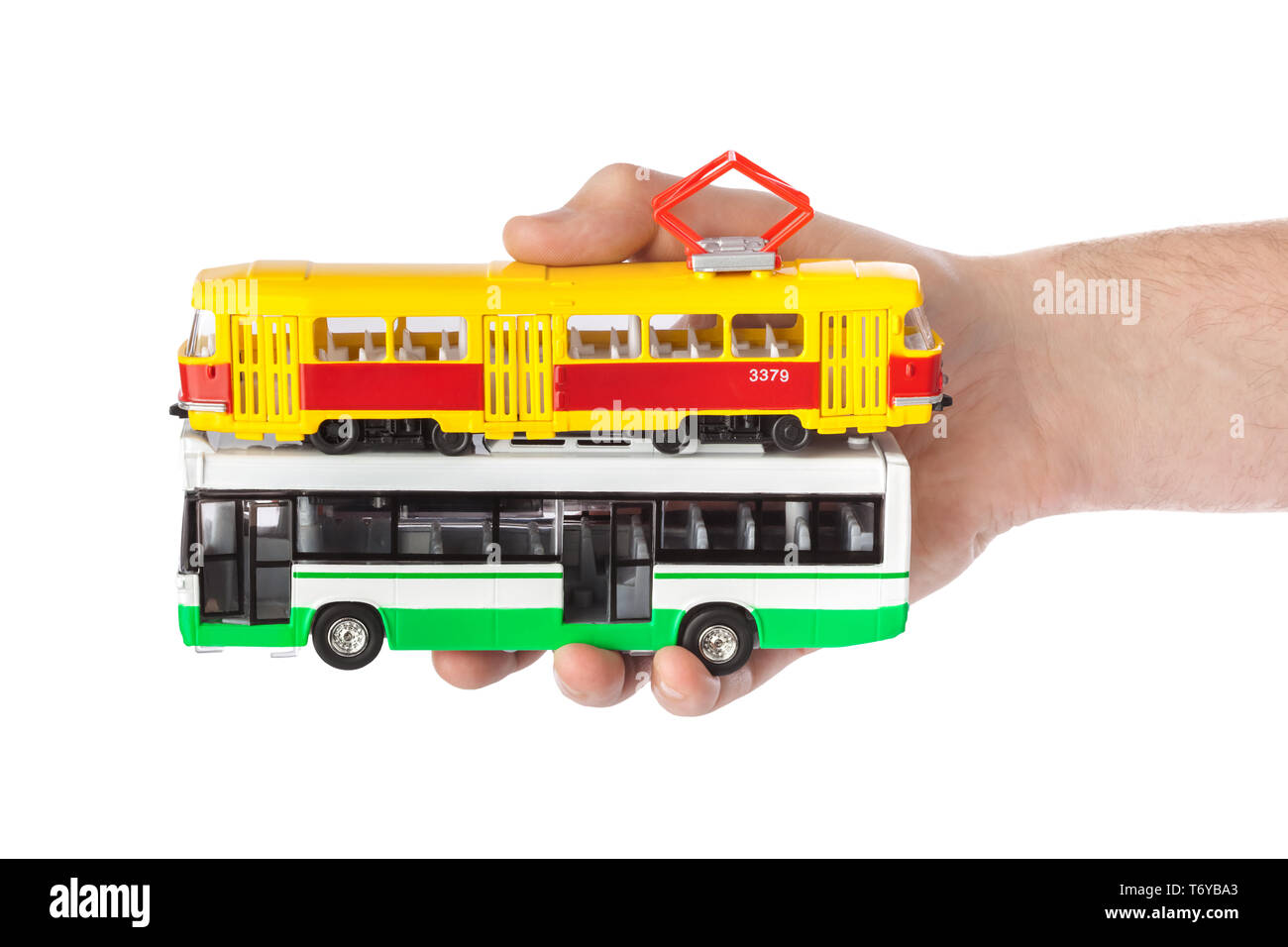 Hand with toy bus and tram Stock Photo - Alamy