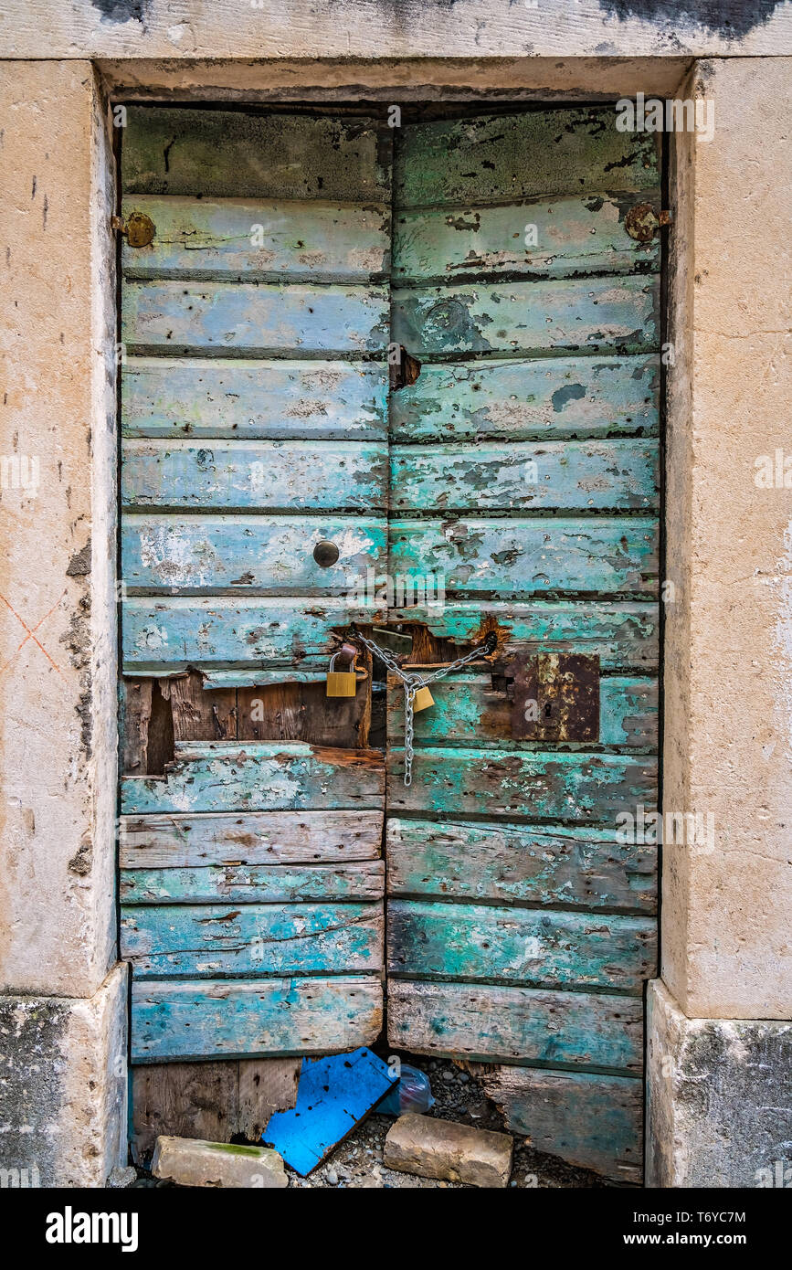 Locked old green damaged wooden doors Stock Photo - Alamy