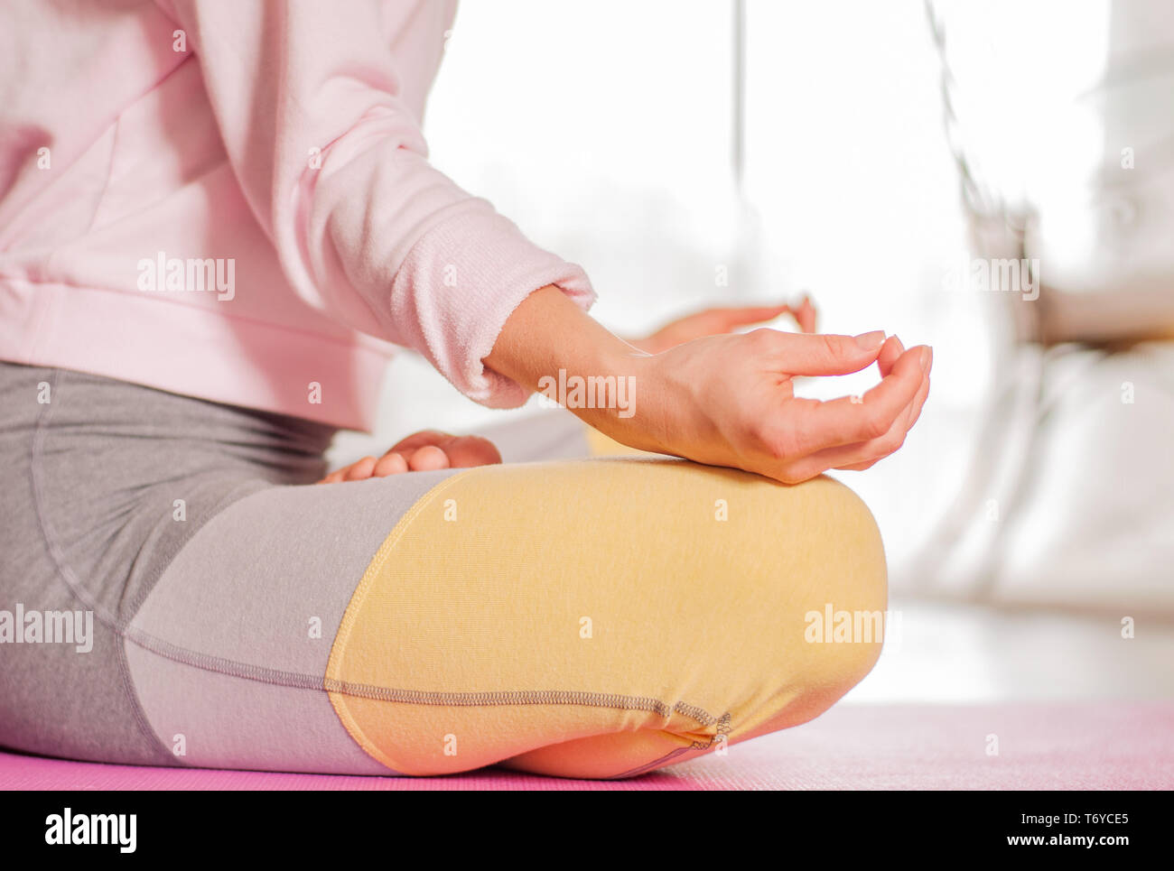 Meditation. Woman is practicing yoga sitting in Lotus pose at home ...