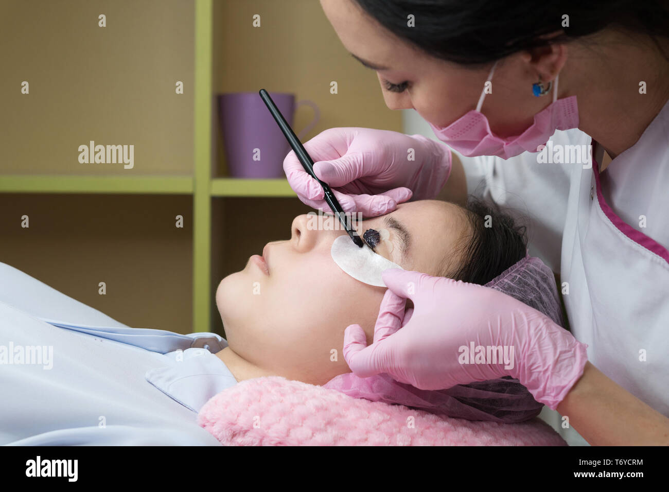 Eyelash extension procedure. Female eyes with long eyelashes. Cosmetic ...