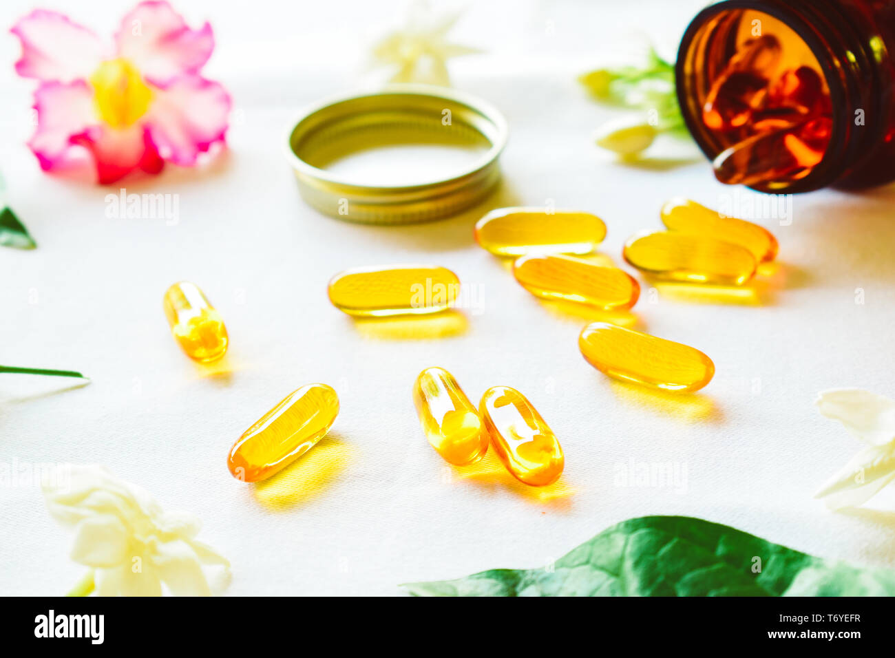 Omega 3 soft gel capsules are decorated with colored flowers over the ...