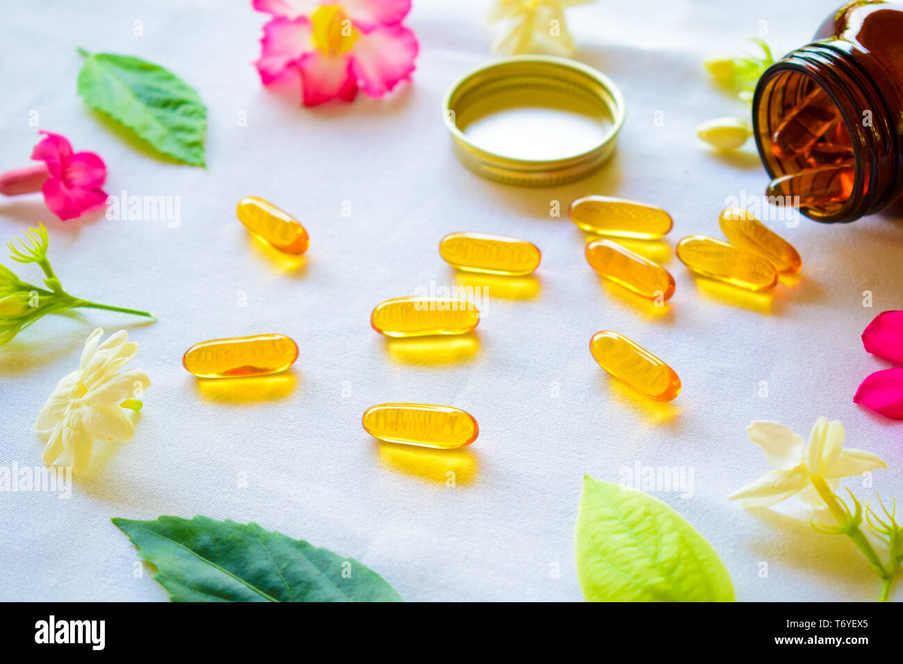 Omega 3 soft gel capsules are decorated with colored flowers over the ...