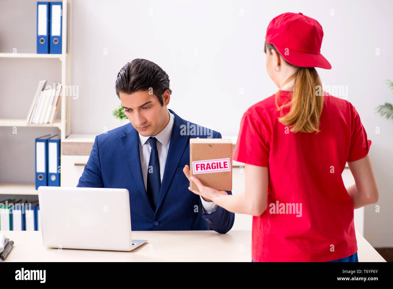Courier delivering parcel to the office Stock Photo - Alamy