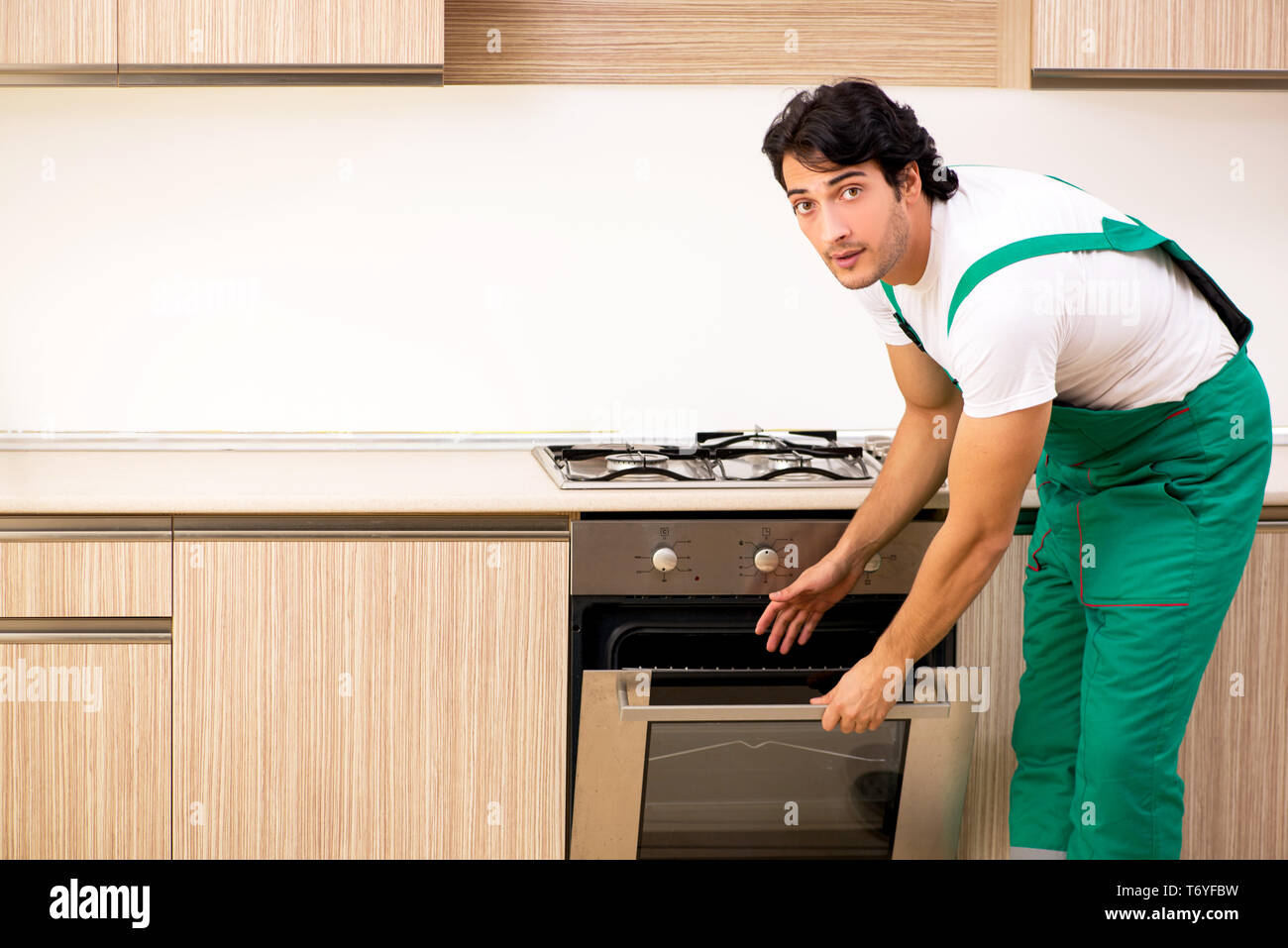 Young contractor repairing oven hi-res stock photography and images - Alamy