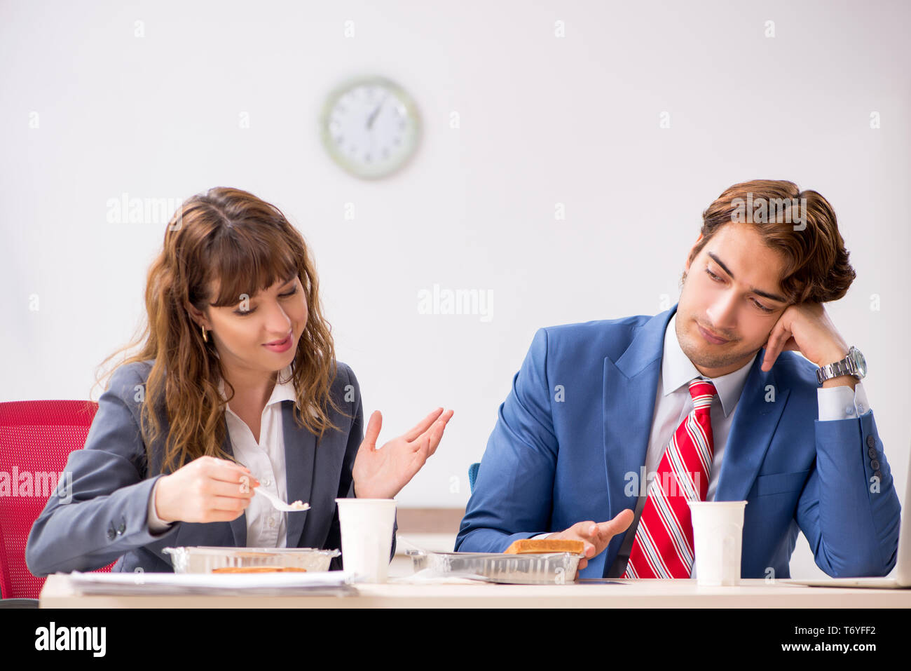 Two colleagues having lunch break at workplace Stock Photo - Alamy