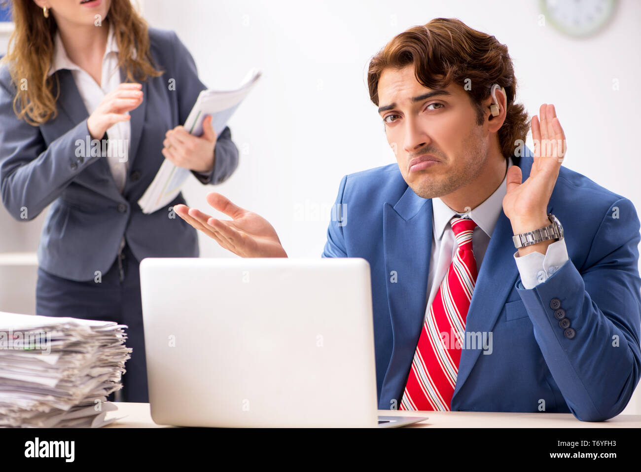 Deaf employee using hearing aid talking to boss Stock Photo - Alamy