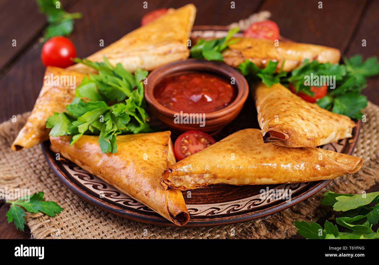 Asian food. Samsa (samosas) with chicken fillet and cheese on wooden ...