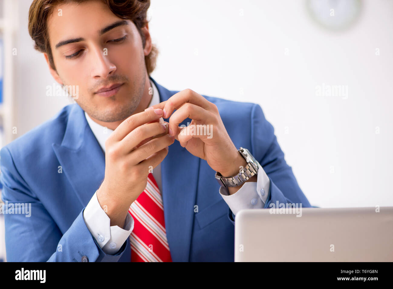 Deaf employee using hearing aid in office Stock Photo - Alamy