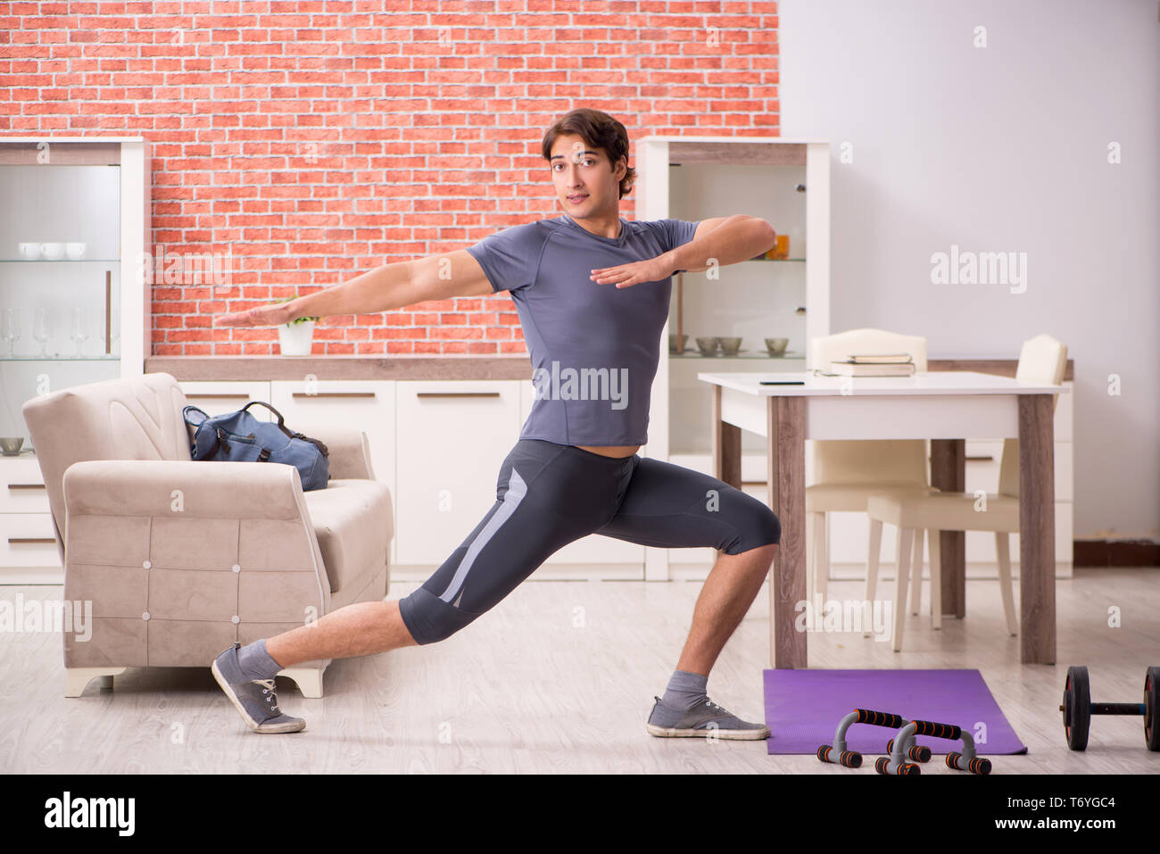 Handsome muscular young man exercises dumbbells hi-res stock ...