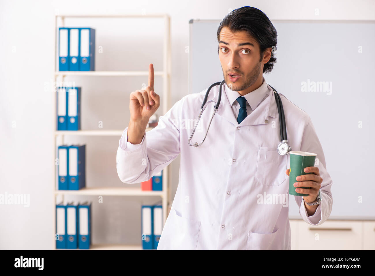 Young doctor drinking coffee in hi-res stock photography and images - Alamy