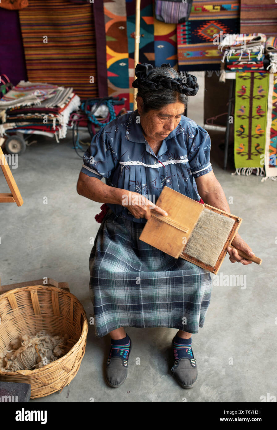 Zapotec woman combing the raw wool to prepare for spinning it on the ...