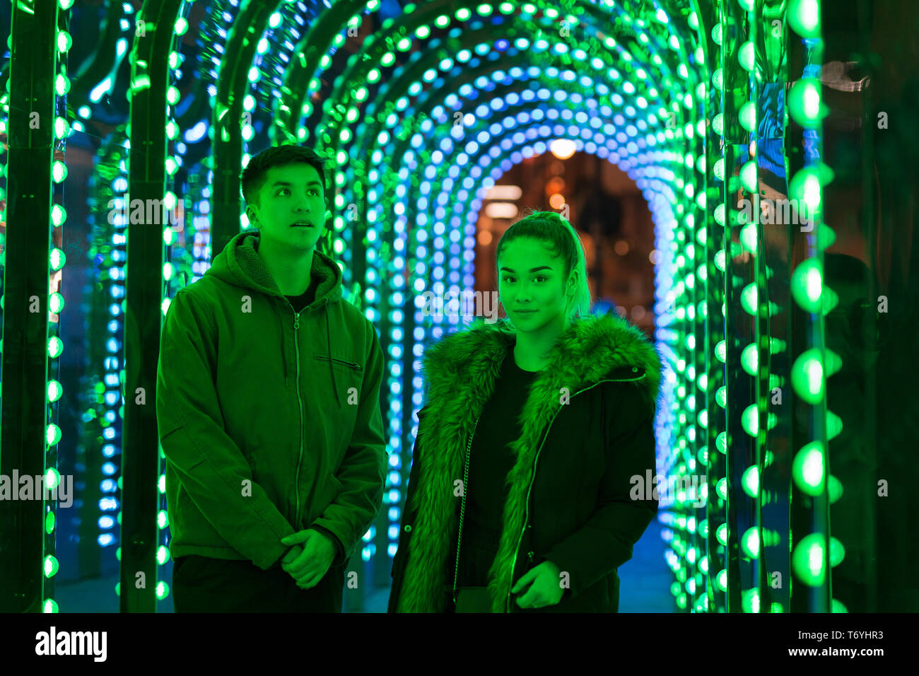 Portrait of mixed race teenage brother and sister standing in green ...