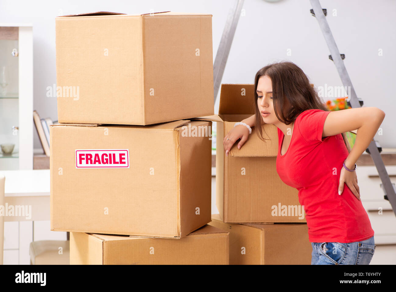 Woman carrying boxes back pain hi-res stock photography and images - Alamy