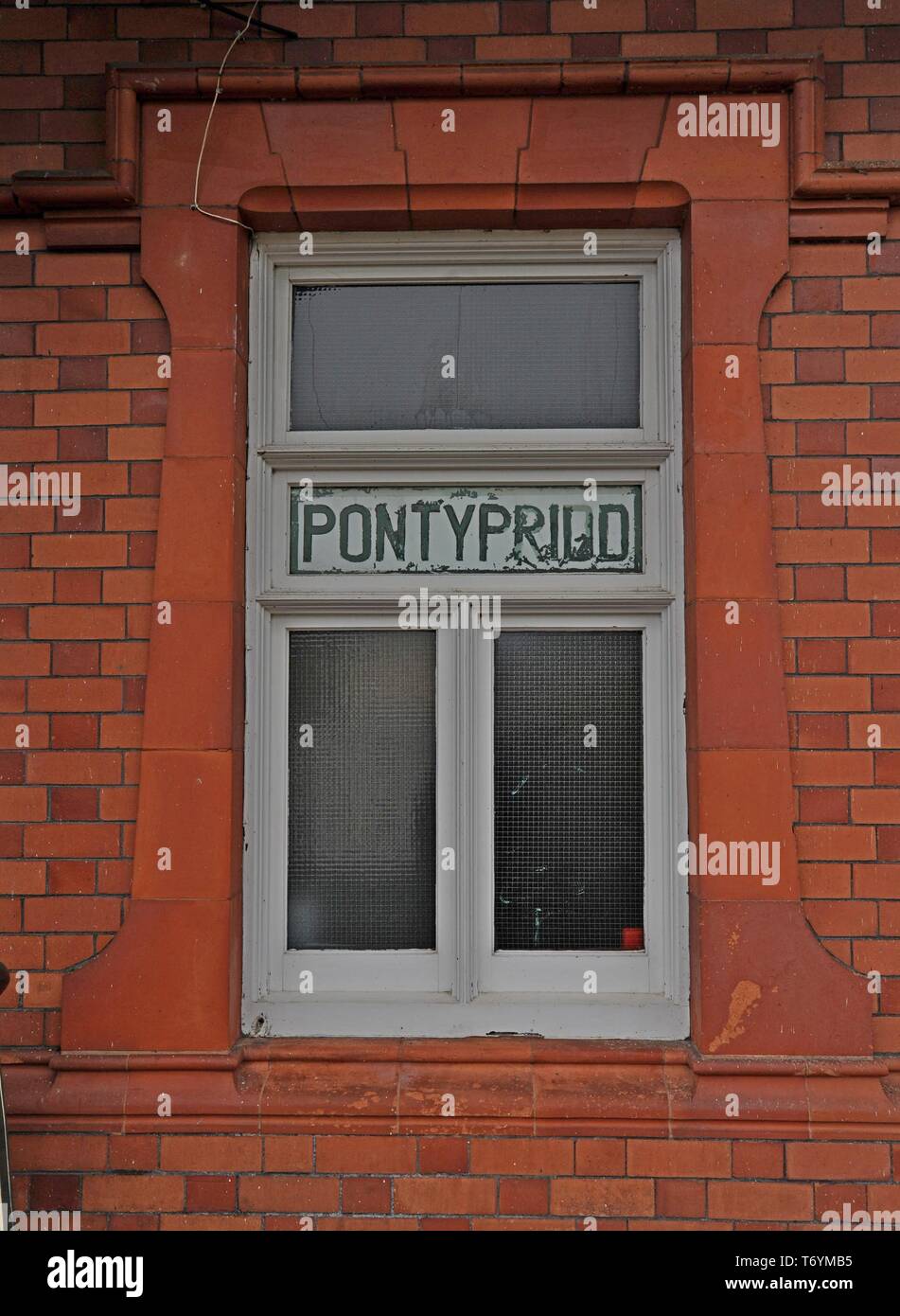 A window with a chipped and faded sign at Pontypridd railway station ...
