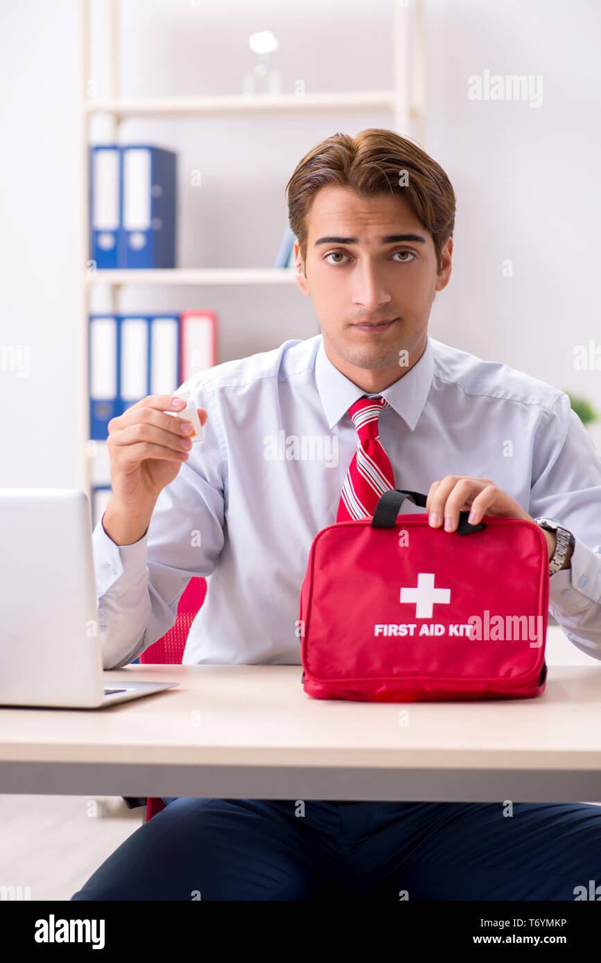 Man with first aid kit in the office Stock Photo - Alamy