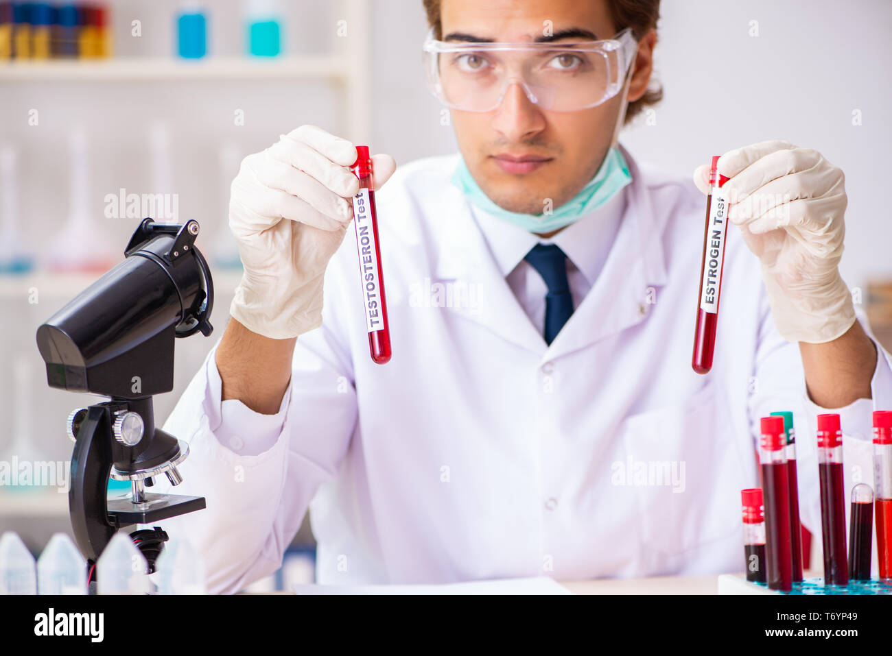 Young handsome lab assistant testing blood samples in hospital Stock ...