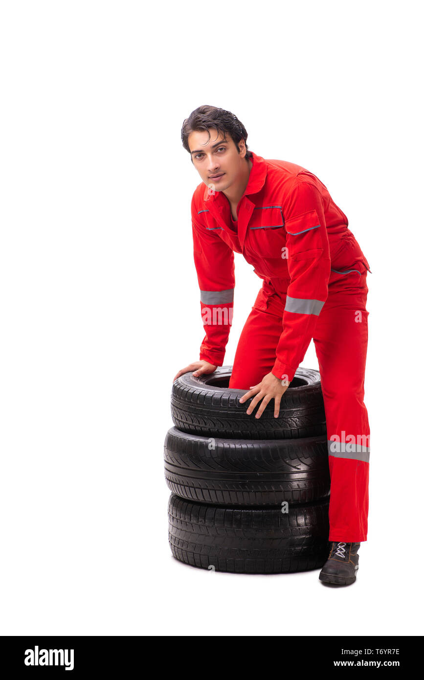 Young garage worker with tyre isolated on white Stock Photo - Alamy