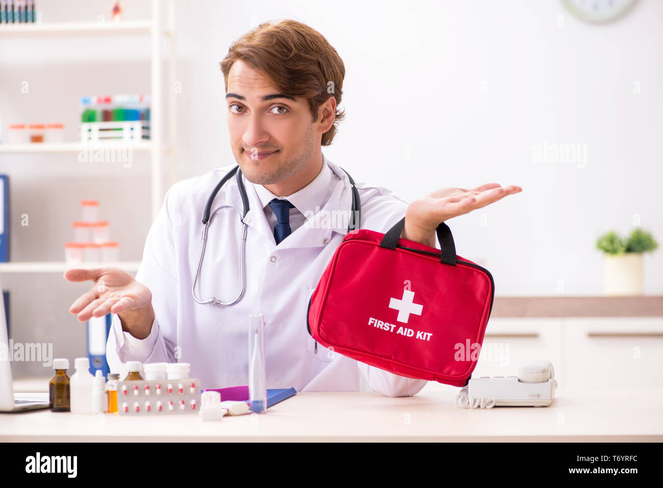 The young doctor with first aid kit in hospital Stock Photo - Alamy