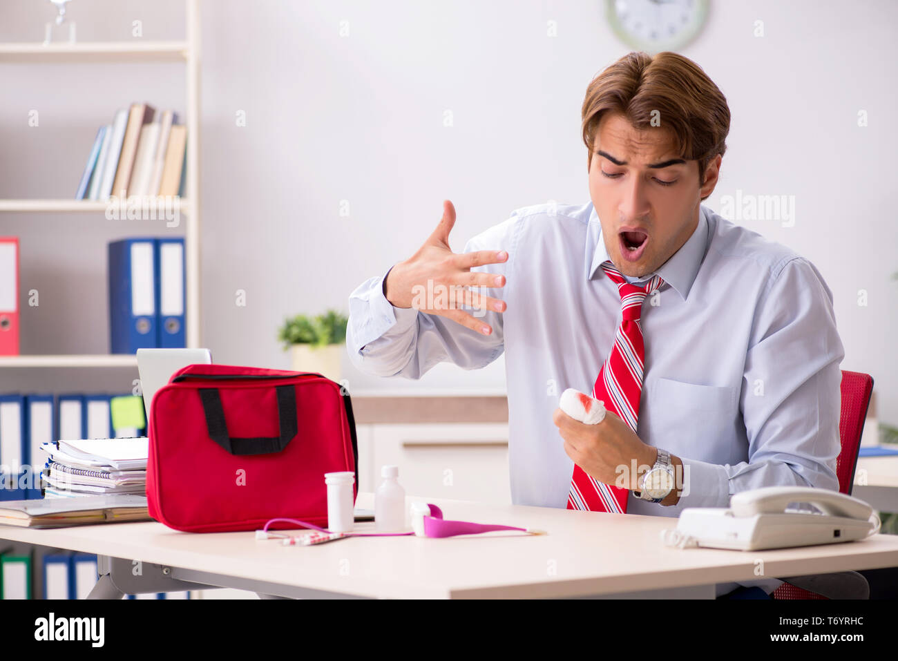 The man with first aid kit in the office Stock Photo - Alamy