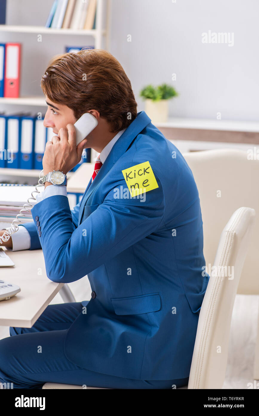 The office prank with kick me message on sticky note Stock Photo - Alamy