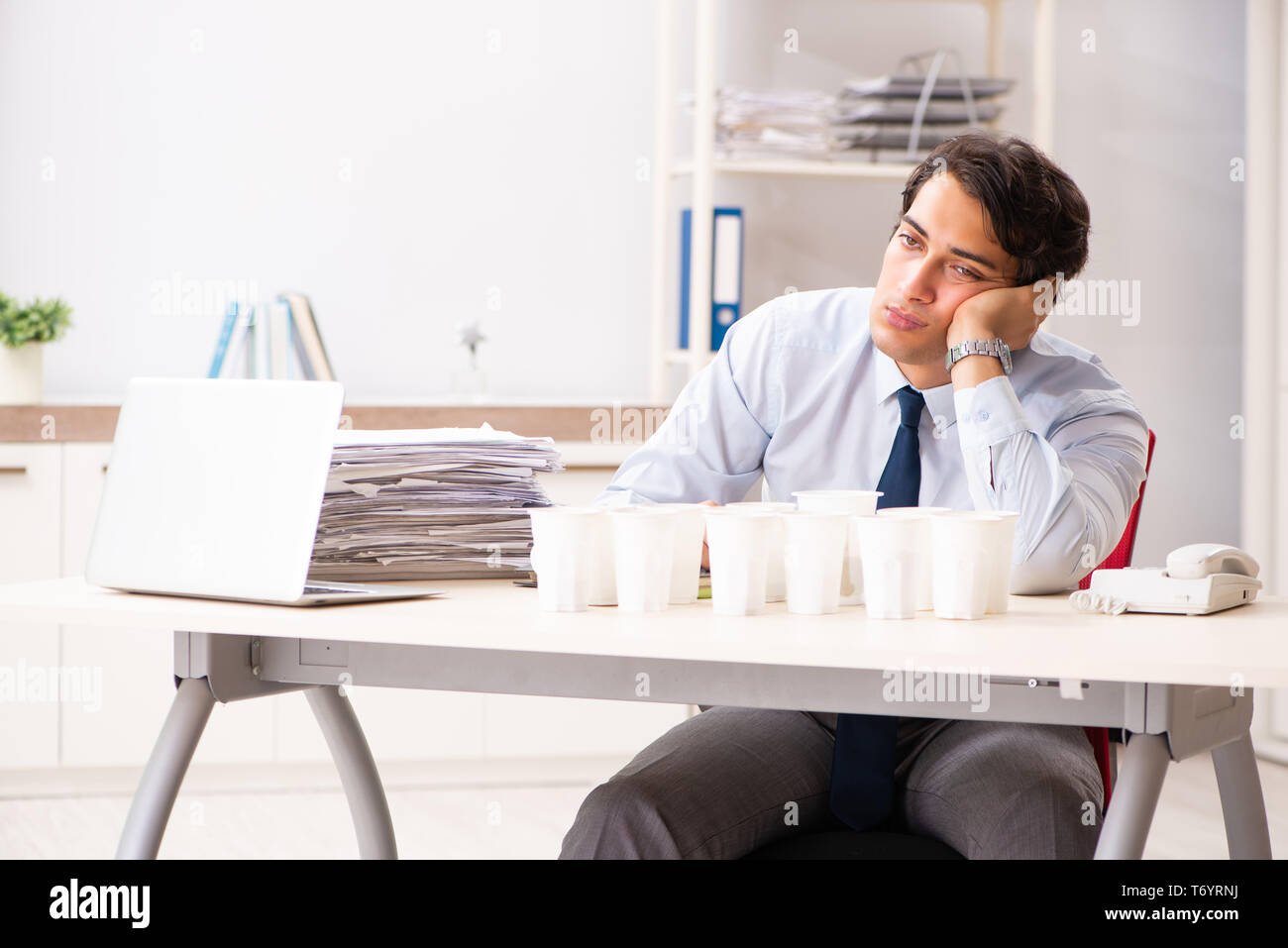 The young employee addicted to coffee Stock Photo - Alamy