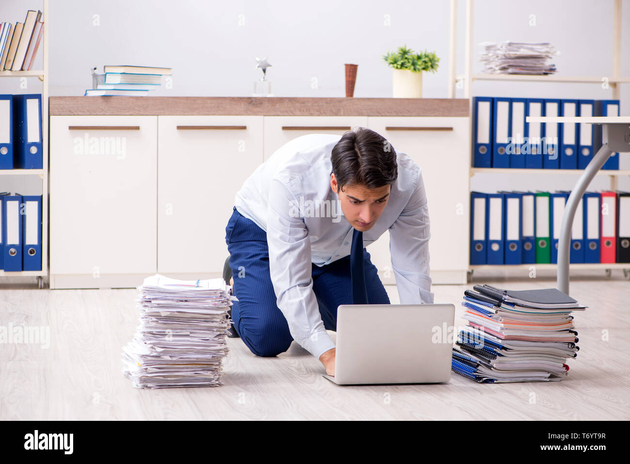 The extremely busy employee working in the office Stock Photo - Alamy